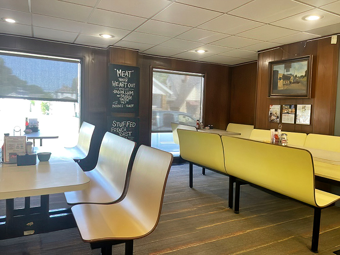 The chalkboard wisdom and yellow booths create the perfect backdrop for meals that taste like childhood memories.