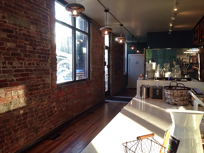 Exposed brick walls and natural light create an atmosphere that says, "Yes, this place takes chicken seriously, but not itself."