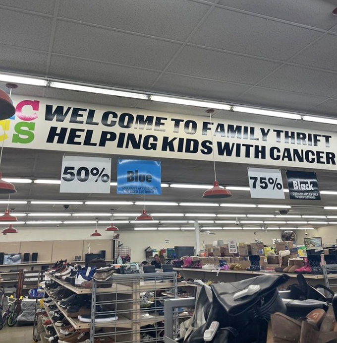 "Helping Kids With Cancer" banner reminds shoppers their bargain hunting serves a greater purpose. Thrift karma is real, and it feels fantastic.