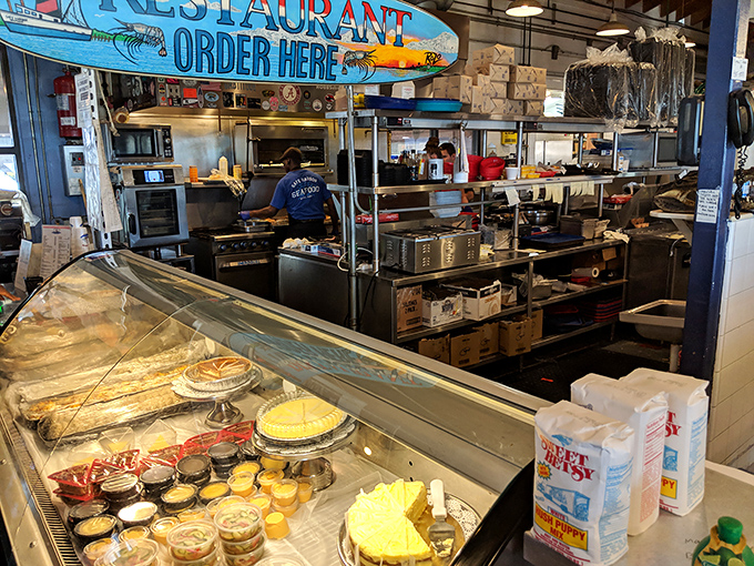 The kitchen view reveals the beautiful chaos of fresh seafood preparation – where ocean treasures transform into plate perfection.