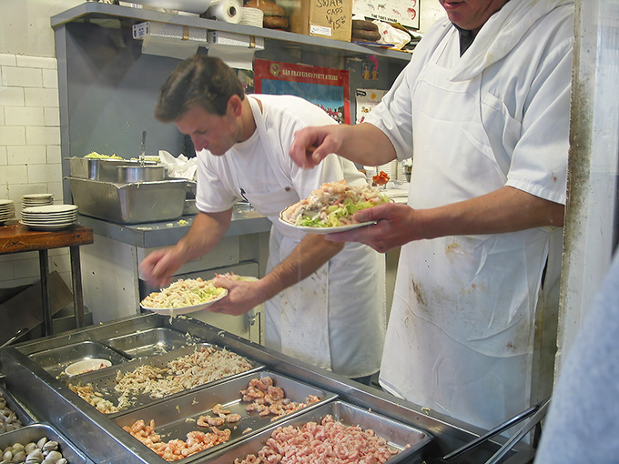 The kitchen dance &ndash; skilled hands transforming the ocean's bounty into edible art. No fancy techniques, just respectful preparation of exceptional ingredients.