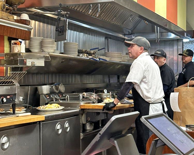 Kitchen choreography at its finest. These aren't just cooks; they're breakfast conductors orchestrating the symphony of sizzle and steam.
