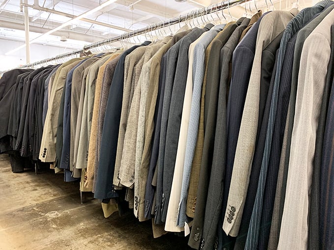 Men's blazers and sport coats hang like patient gentlemen, each one whispering, "I could make you look distinguished for less than lunch."