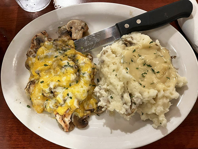 Monterey chicken that doesn't know the meaning of restraint: grilled chicken smothered in mushrooms, melted cheese, and served with mashed potatoes worthy of their own fan club.