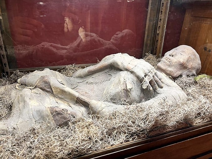 This mummified figure reclines in its display case, looking like it had a really, really bad day at the spa.