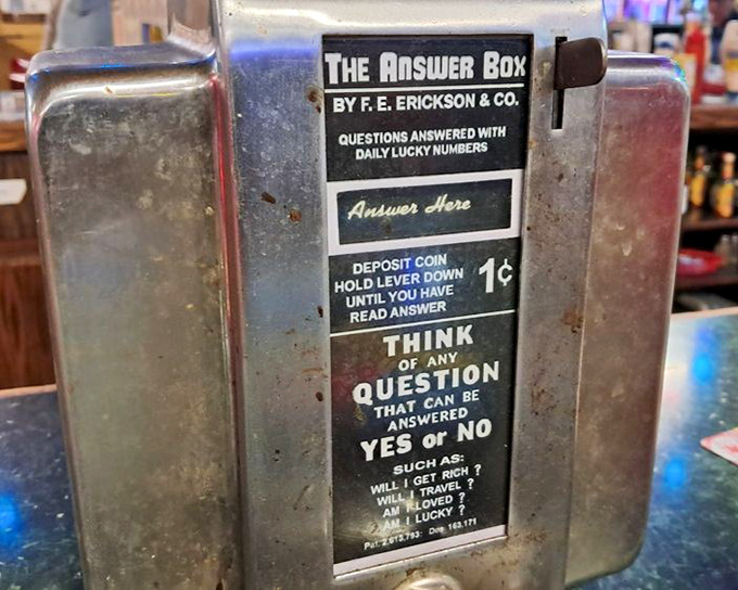 The vintage "Answer Box" sits like a mechanical fortune teller, dispensing wisdom for a penny while you contemplate ordering dessert.