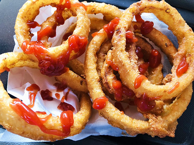 Onion rings dressed in ketchup like they're heading to the prom of your taste buds.