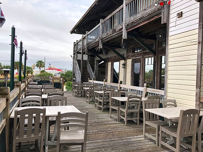 White tables against weathered wood decking create the perfect stage for seafood theater, with water views providing the ideal backdrop.