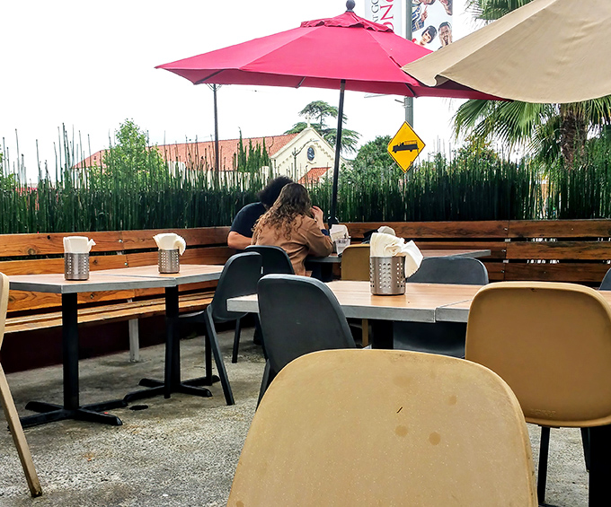 The outdoor patio offers a front-row seat to Eagle Rock life, where red umbrellas provide shade for serious sandwich contemplation.
