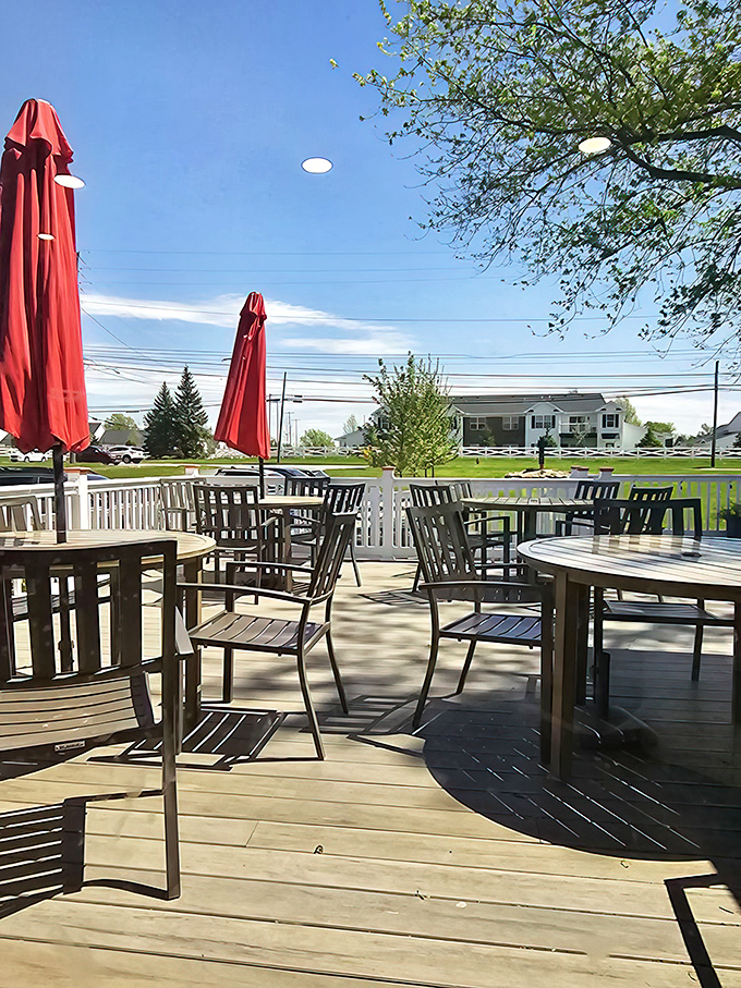 The outdoor patio offers a breath of fresh air between bites. Those red umbrellas stand like sentinels, protecting precious hot dogs from the elements.