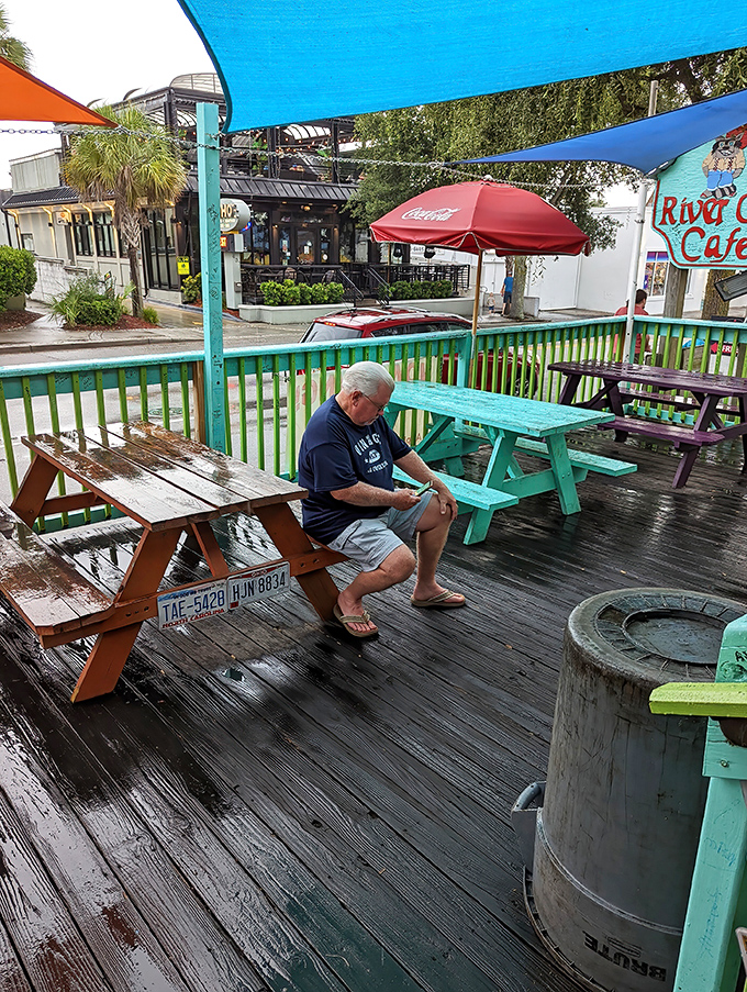 Rain-slicked decks and colorful picnic tables create the perfect coastal vibe. Even in drizzle, this outdoor seating beckons burger enthusiasts.