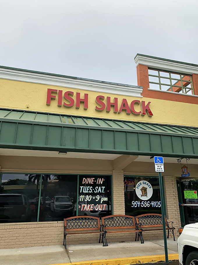 Business hours painted on the window and benches outside&mdash;the universal signal for "worth the wait." That green awning has sheltered many hungry souls.