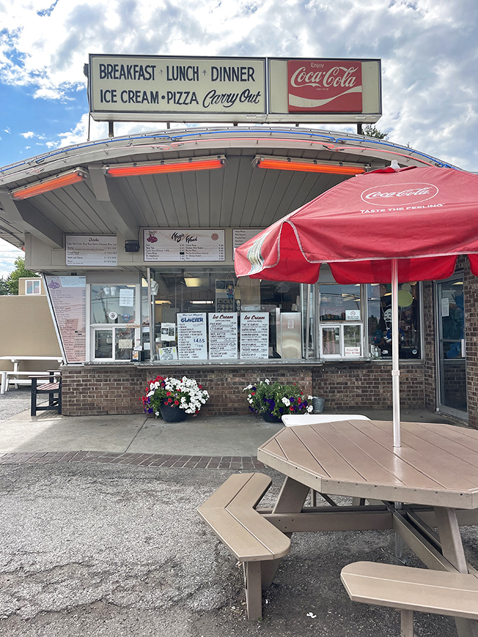 Summer perfection: picnic tables, red umbrellas, and the promise of ice cream. The flower pots add a touch of "we care" to this roadside classic.