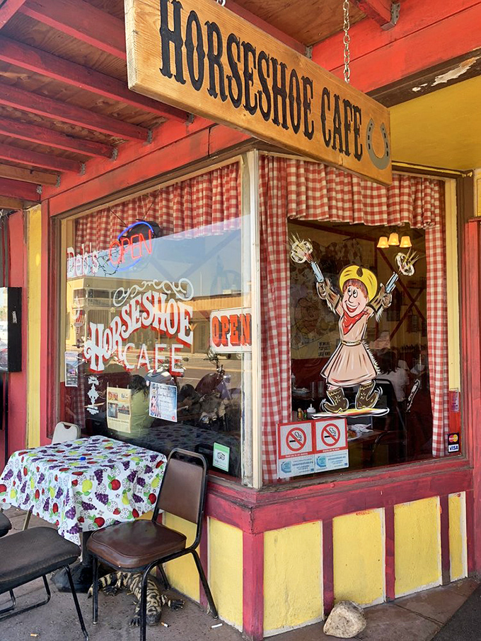 The cafe's cheerful exterior welcomes sidewalk diners with its red and yellow charm and classic western signage.