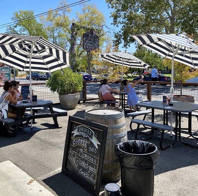 The outdoor patio&mdash;where breakfast meets sunshine under striped umbrellas. Even the barrel seems happy to be part of this alfresco experience.