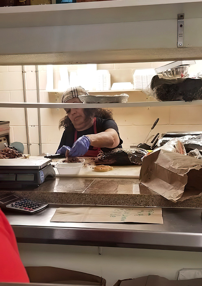 Behind the scenes where smoke meets meat. The gloves tell you they're serious&mdash;good barbecue is hands-on business.