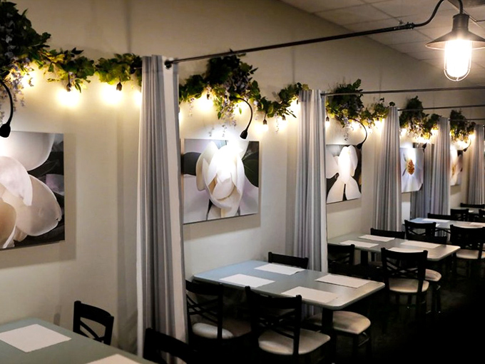 The private dining area elevates cafeteria dining with soft lighting, magnolia artwork, and greenery that makes every meal feel like a special occasion.