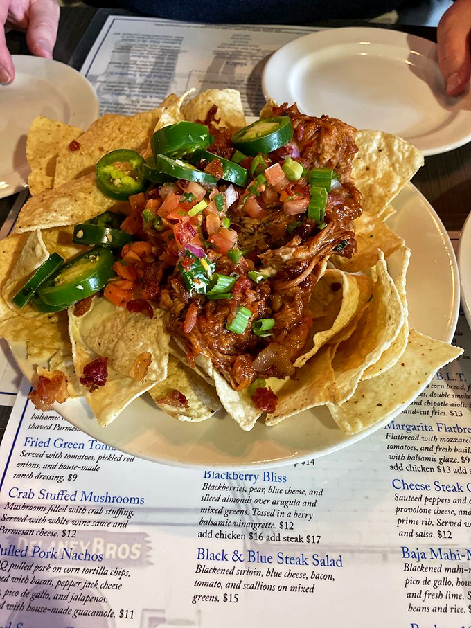 Pulled pork nachos that don't mess around—loaded with jalapeños, fresh pico, and enough cheese to make Wisconsin nervous.