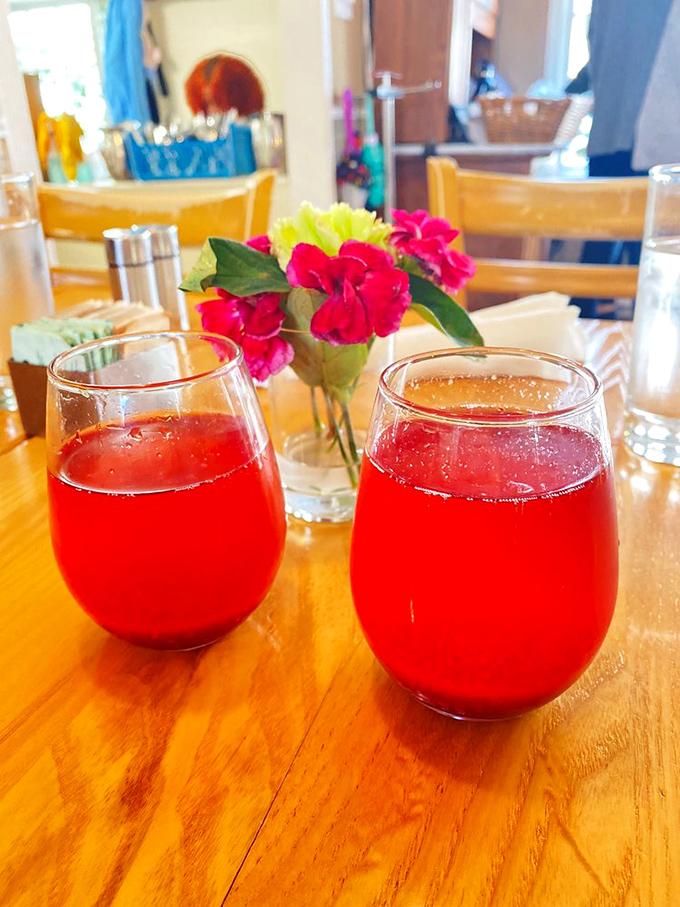 Two ruby-red mimosas catching the light like liquid gemstones—proof that breakfast cocktails are nature's way of saying "good morning" with enthusiasm.