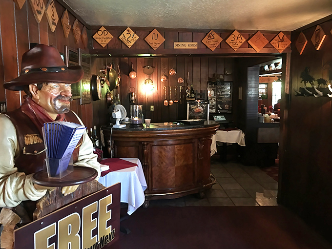 A cowboy greeter stands sentinel by the host stand, his wooden expression never changing despite witnessing thousands of "I'm so full" departures.