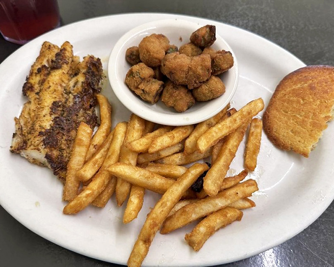 A plate that says "we don't just do breakfast"&mdash;golden fish, crispy fries, and what appears to be hush puppies form the holy trinity of Southern lunch specials.