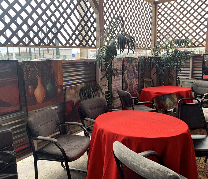 Red tablecloths and simple chairs create intimate dining islands where food becomes the center of attention.