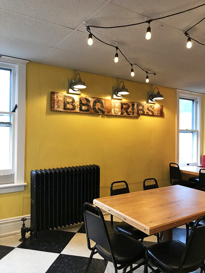 The "BBQ RIBS" sign serves as both d&eacute;cor and life philosophy in a room designed for serious eating, not fancy pretenses.