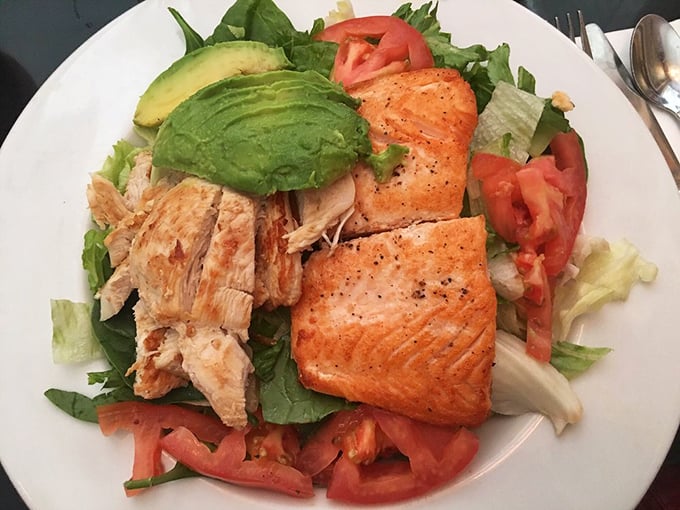 A protein powerhouse disguised as a salad. Salmon, chicken, avocado, and fresh vegetables create a lunch that's both virtuous and satisfying.
