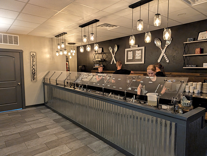 The salad bar counter gleams under mason jar lights, promising fresh starters before the main event. Midwestern practicality meets modern design.