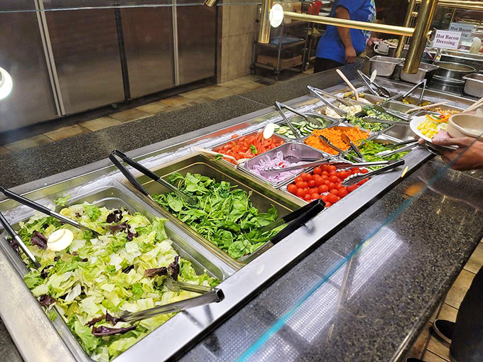 A fresh and colorful salad bar offers a variety of crisp greens, veggies, and toppings ready to be customized to your taste.