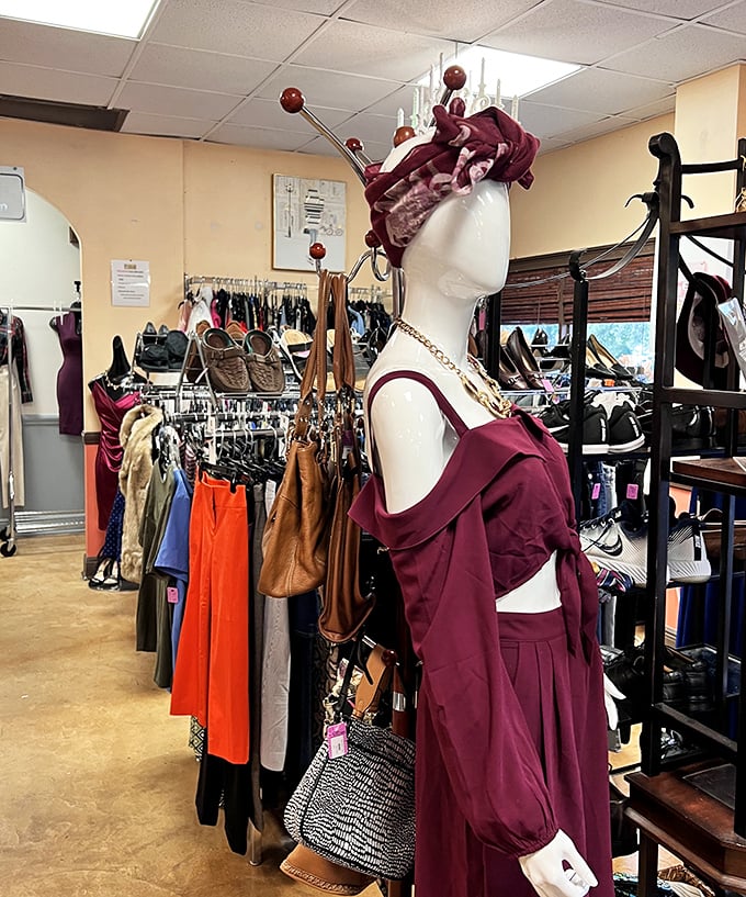 A mannequin modeling burgundy elegance that screams "I cost $200 elsewhere!" The accessories wall behind offers supporting characters for your wardrobe drama.