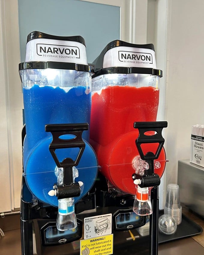 Slushie machines standing like colorful sentinels of refreshment. Red and blue, locked in an eternal flavor battle that you'll happily referee.