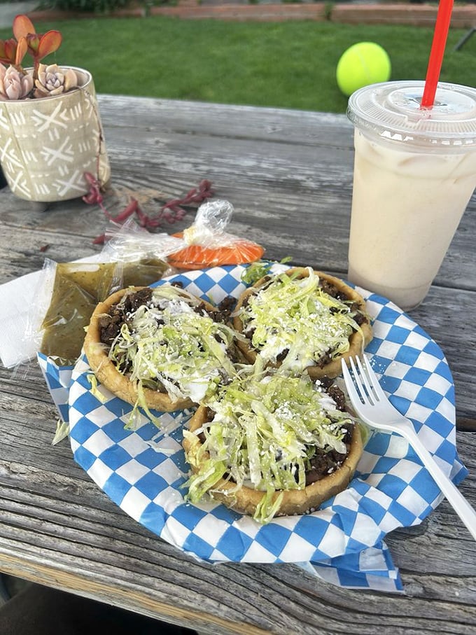 Sopes that serve as edible plates for carne asada glory. The thick, hand-formed corn bases cradle layers of beans, meat, lettuce, and cheese in perfect harmony.