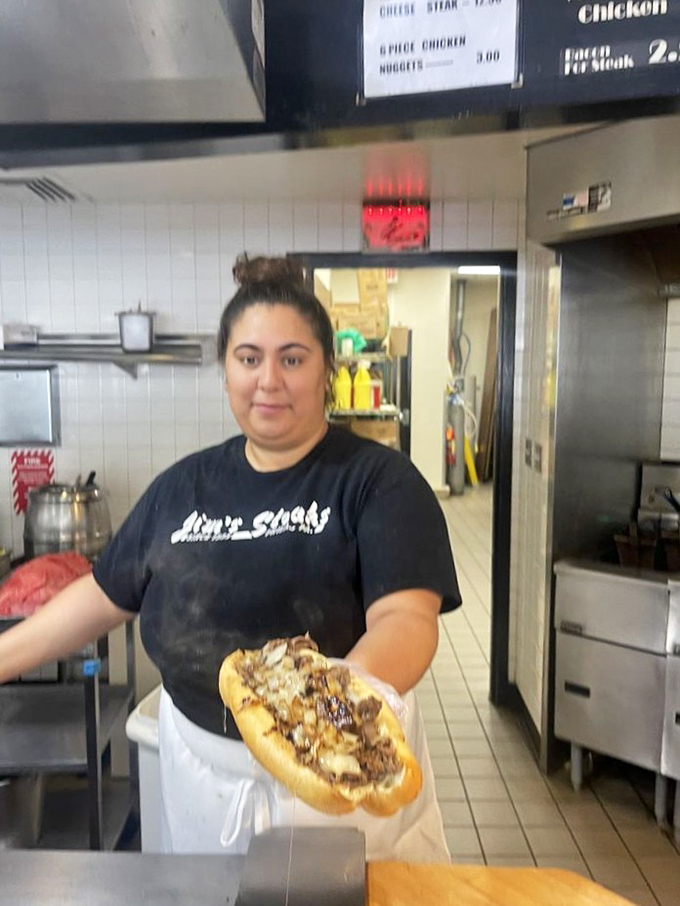 The artisans behind the magic, crafting each sandwich with practiced precision. These hands know their way around a cheesesteak.