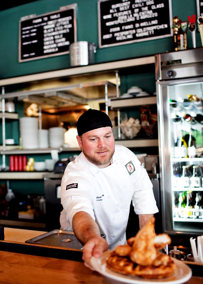 The maestro at work, delivering chicken and waffles with the confidence of someone who knows they're changing your day for the better.