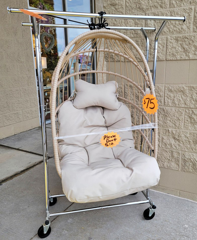 The hanging chair that's saying "buy me" while the sign is saying "don't sit." A thrifter's classic dilemma.