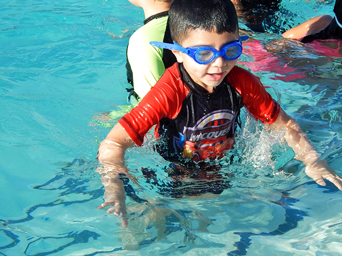 Childhood summer joy captured in turquoise waters &ndash; where swimming lessons and Marco Polo games create memories that last far longer than pruney fingers.