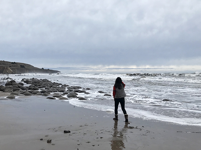 Solitude with a view. One visitor contemplates the vastness of the Pacific while bowling ball rocks play hide-and-seek with the waves.