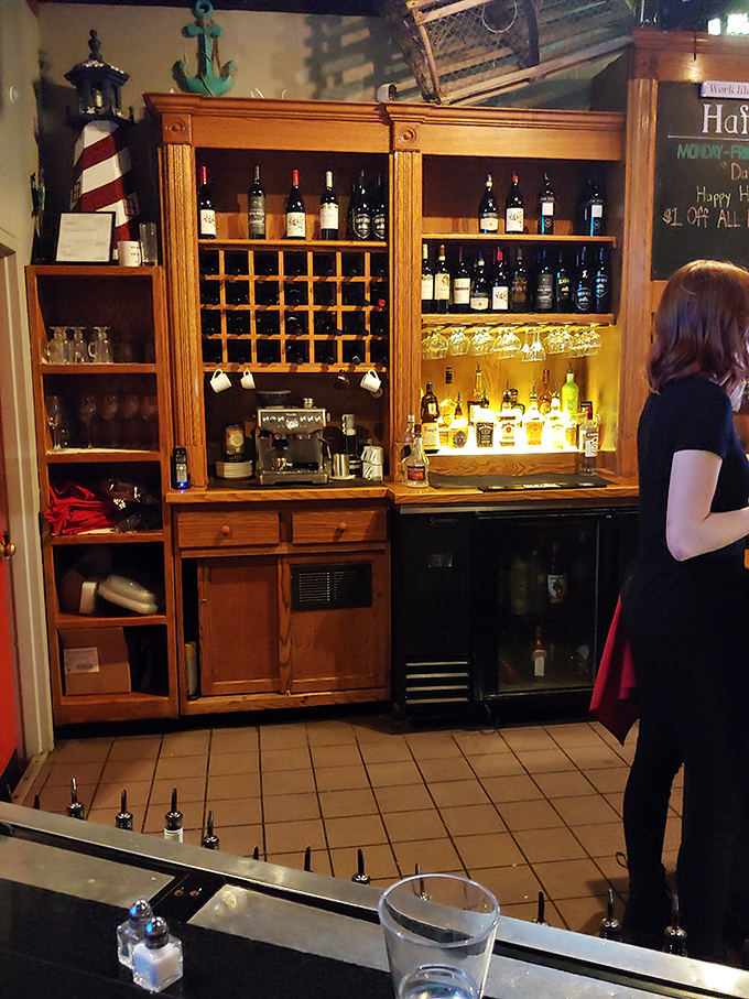 The bar area doesn't just serve drinks&mdash;it creates liquid companions for your seafood journey. That wooden wine rack holds bottles of potential memories.