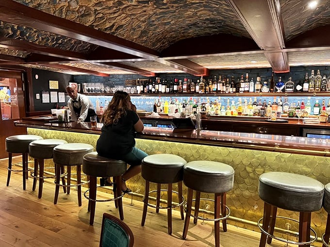 The bar's scale-like backdrop shimmers like fish passing through deep waters&mdash;a perfect visual metaphor for the liquid treasures waiting to be discovered in each glass.