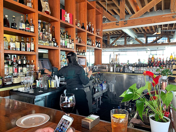 The bar shelves stand like a liquid library of possibilities, where skilled mixologists craft the perfect companion to your seafood feast.