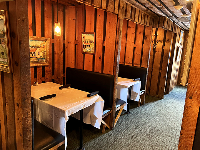 These intimate booth seating areas aren't just tables &ndash; they're private dining nooks where white tablecloths meet rustic wooden walls.