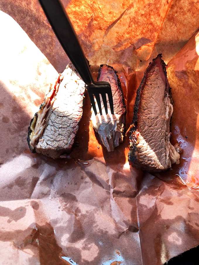 Brisket sliced against the grain revealing that telltale pink smoke ring&mdash;the barbecue equivalent of a diamond necklace. Meat jewelry at its finest.