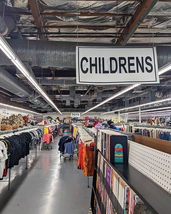 Under the "CHILDRENS" sign, tiny wardrobes await growth spurts, while books stand ready to spark young imaginations without breaking parents' budgets.