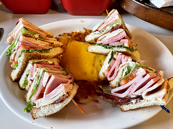 Triple-stacked club sandwich perfection that makes you wonder why anyone settles for ordinary lunch options.