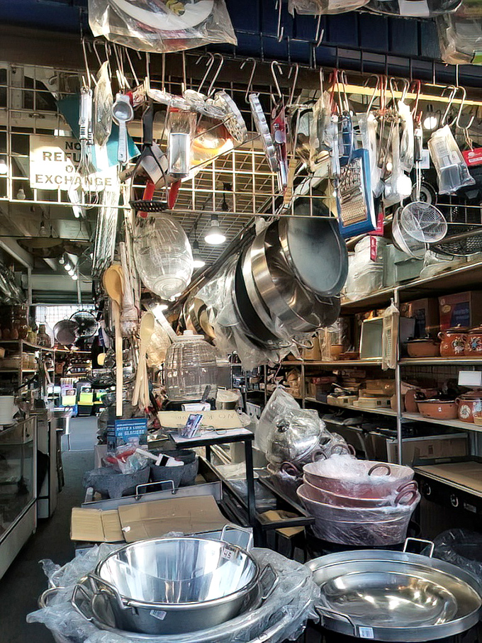 Kitchen equipment dangling like metallic stalactites. This cookware booth is a chef's dream and a minimalist's nightmare.