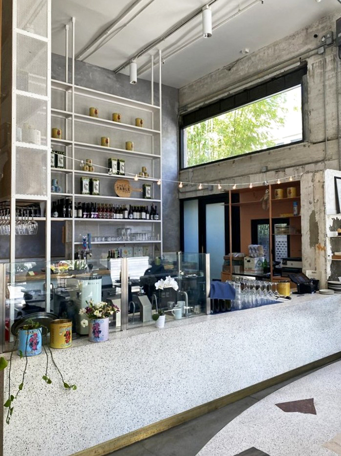 The bar area combines industrial chic with warm functionality. Those shelves have seen countless first dates, celebrations, and "I needed pizza" emergencies.