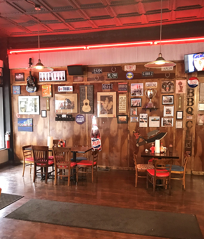 Red neon casts a glow that says "something delicious happens here." License plates and memorabilia create the perfect backdrop for meat-induced euphoria.