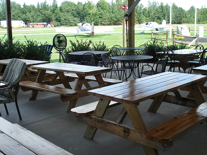 The covered patio offers shelter, picnic tables, and the promise of upcoming feasts. Just beyond sits the airstrip where pilots land for lunch.