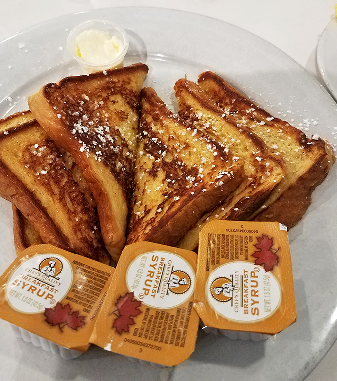 French toast that's achieved golden-brown perfection, dusted with powdered sugar and waiting for its maple syrup baptism.